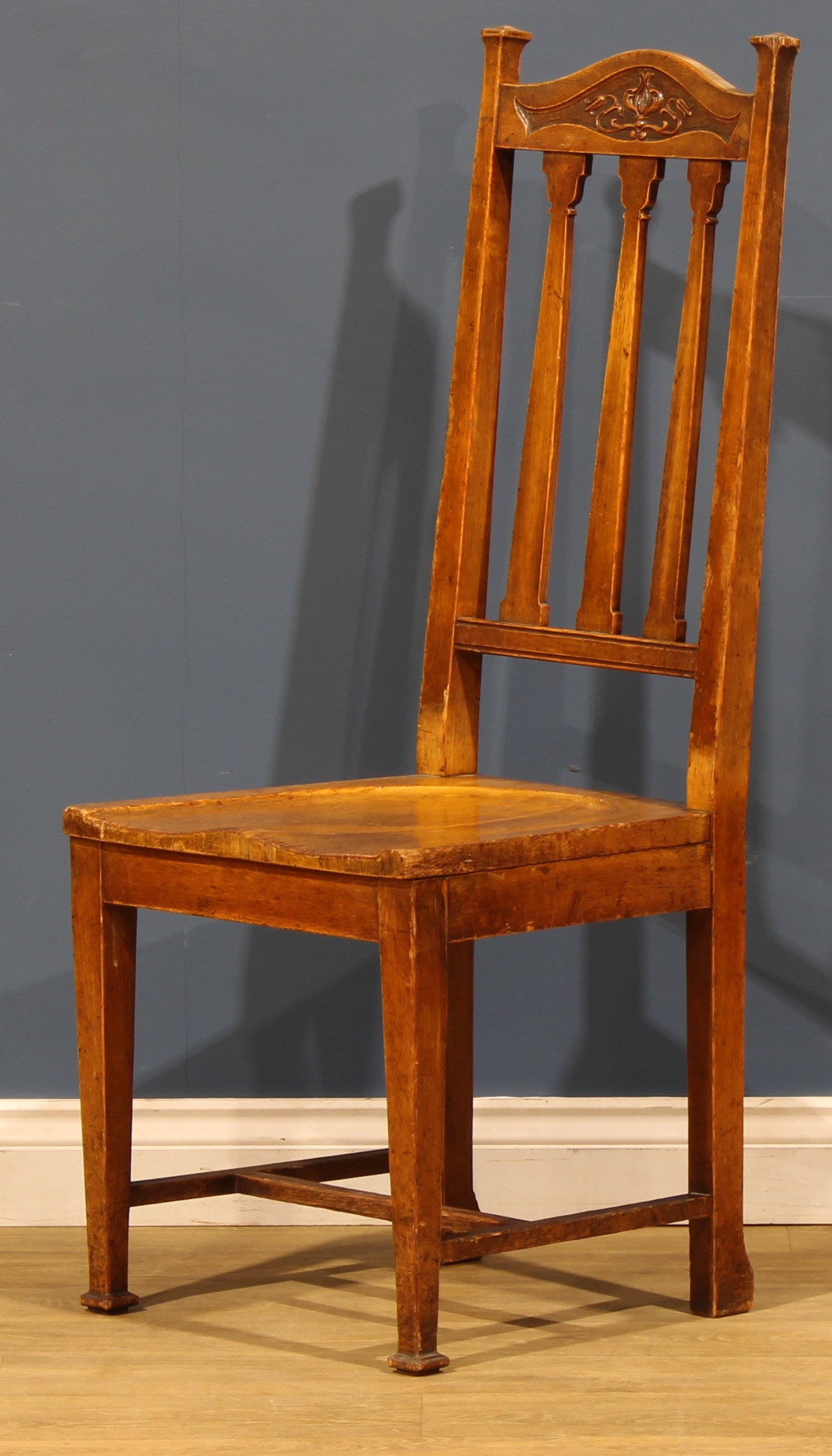 A set of twenty-four Arts & Crafts oak dining chairs, each cresting ...