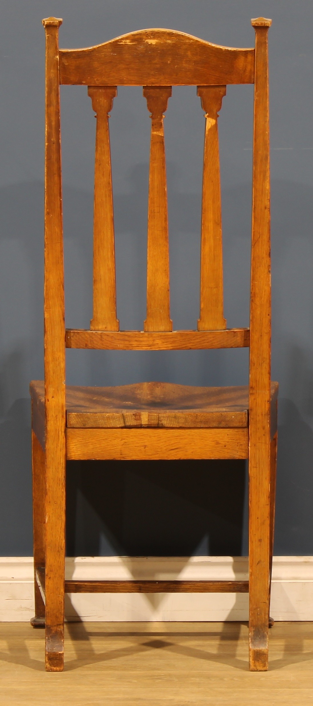A set of twenty-four Arts & Crafts oak dining chairs, each cresting ...