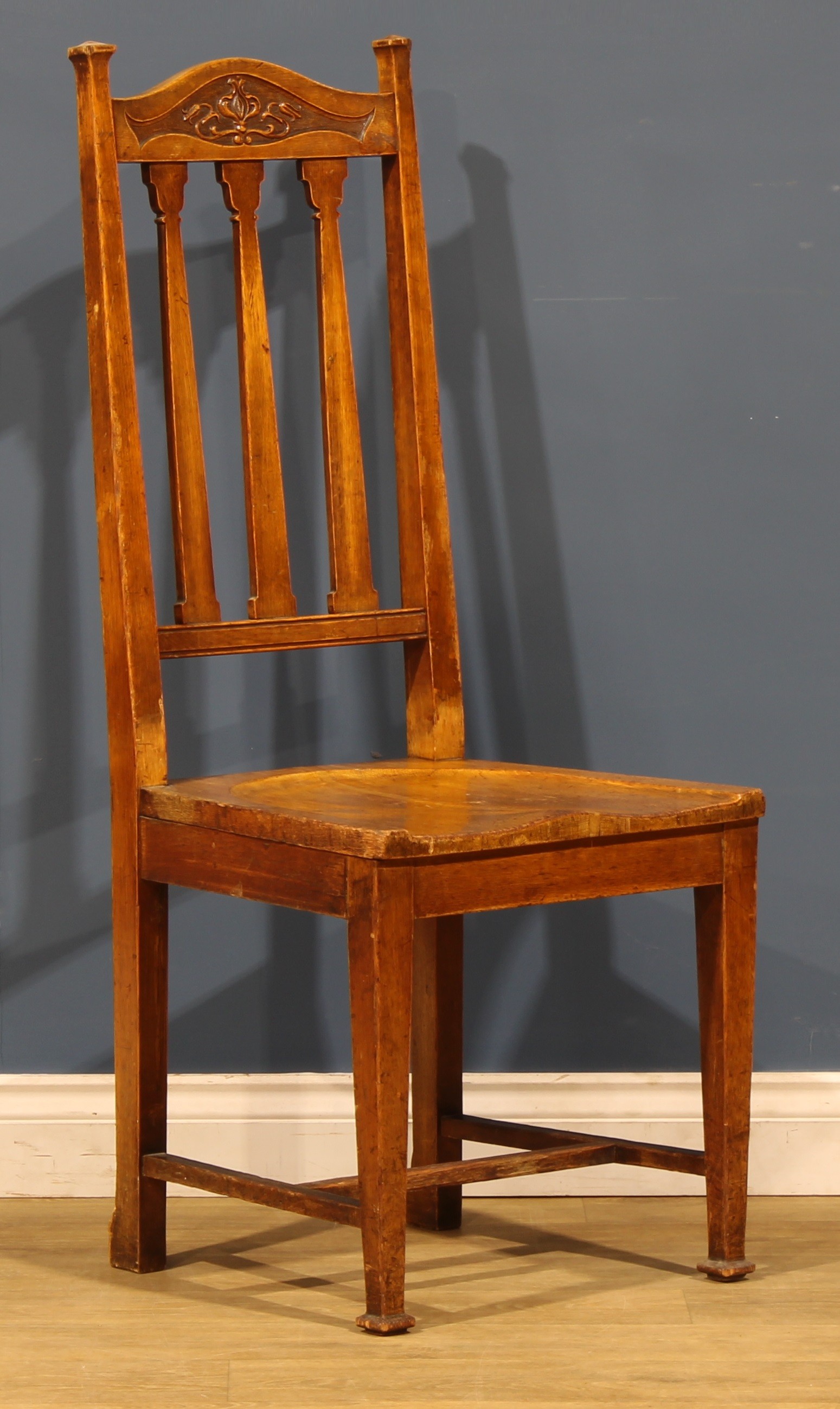 A set of twenty-four Arts & Crafts oak dining chairs, each cresting ...