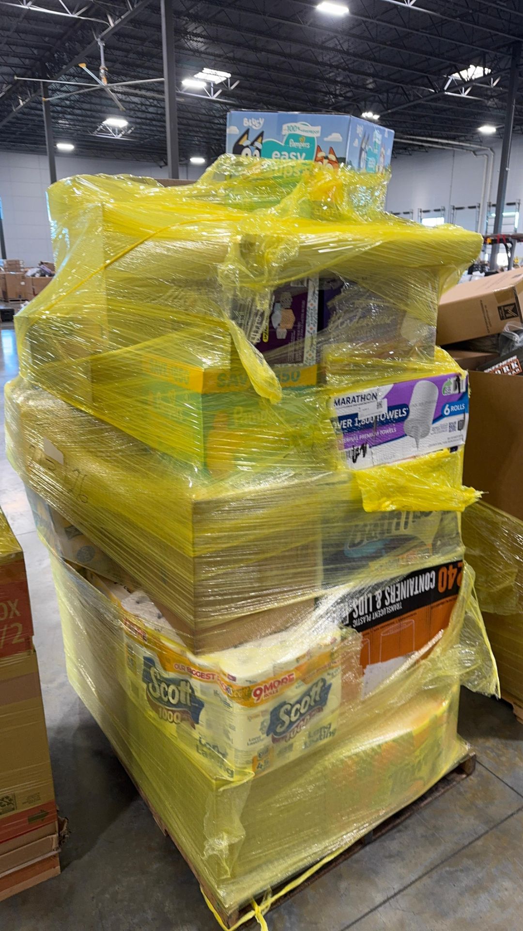 tall pallet full of paper towels, toilet paper, Crock-Pot diapers and more