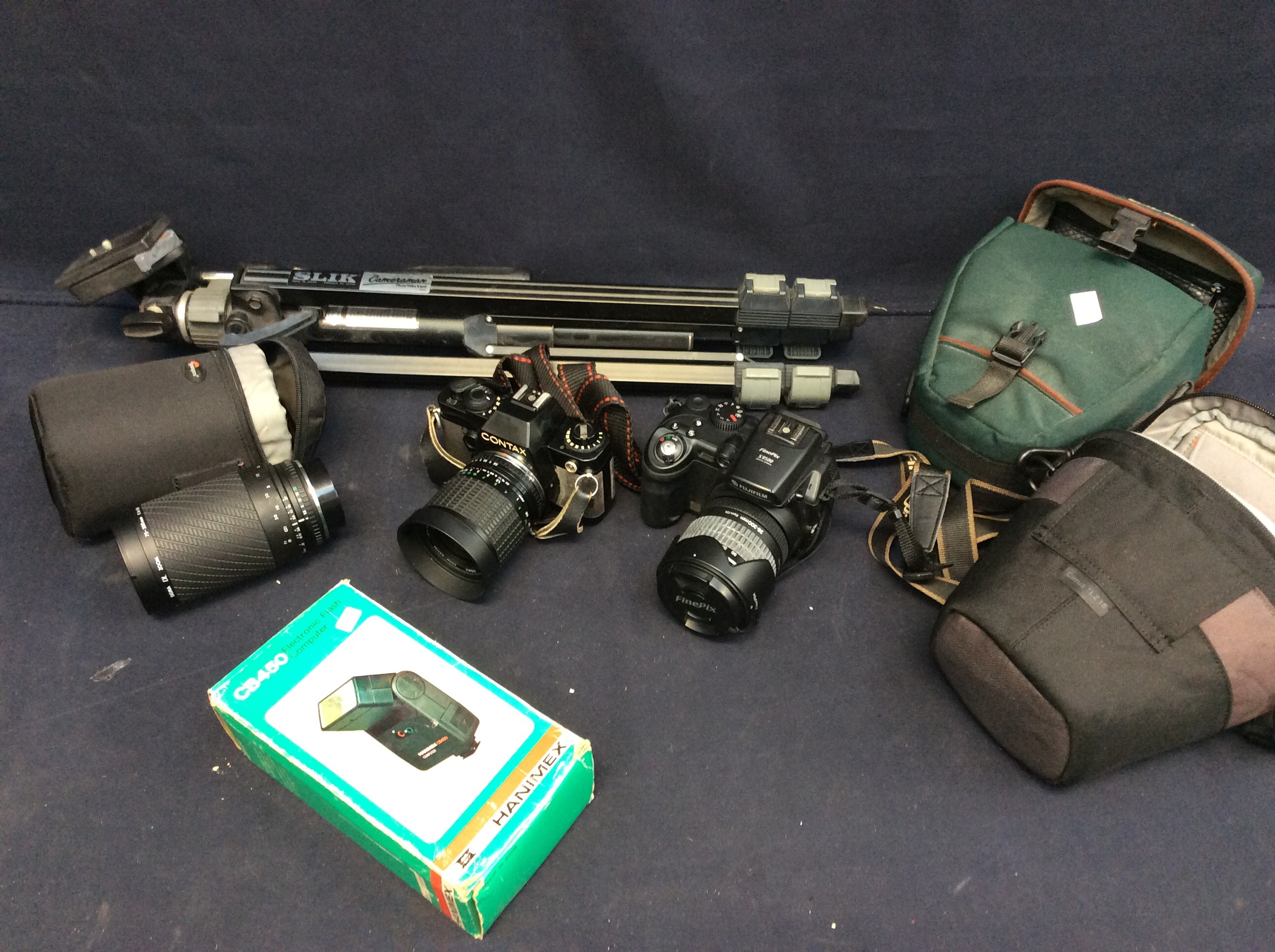 A collection of vintage cameras with tripod and flash with cased lense ...