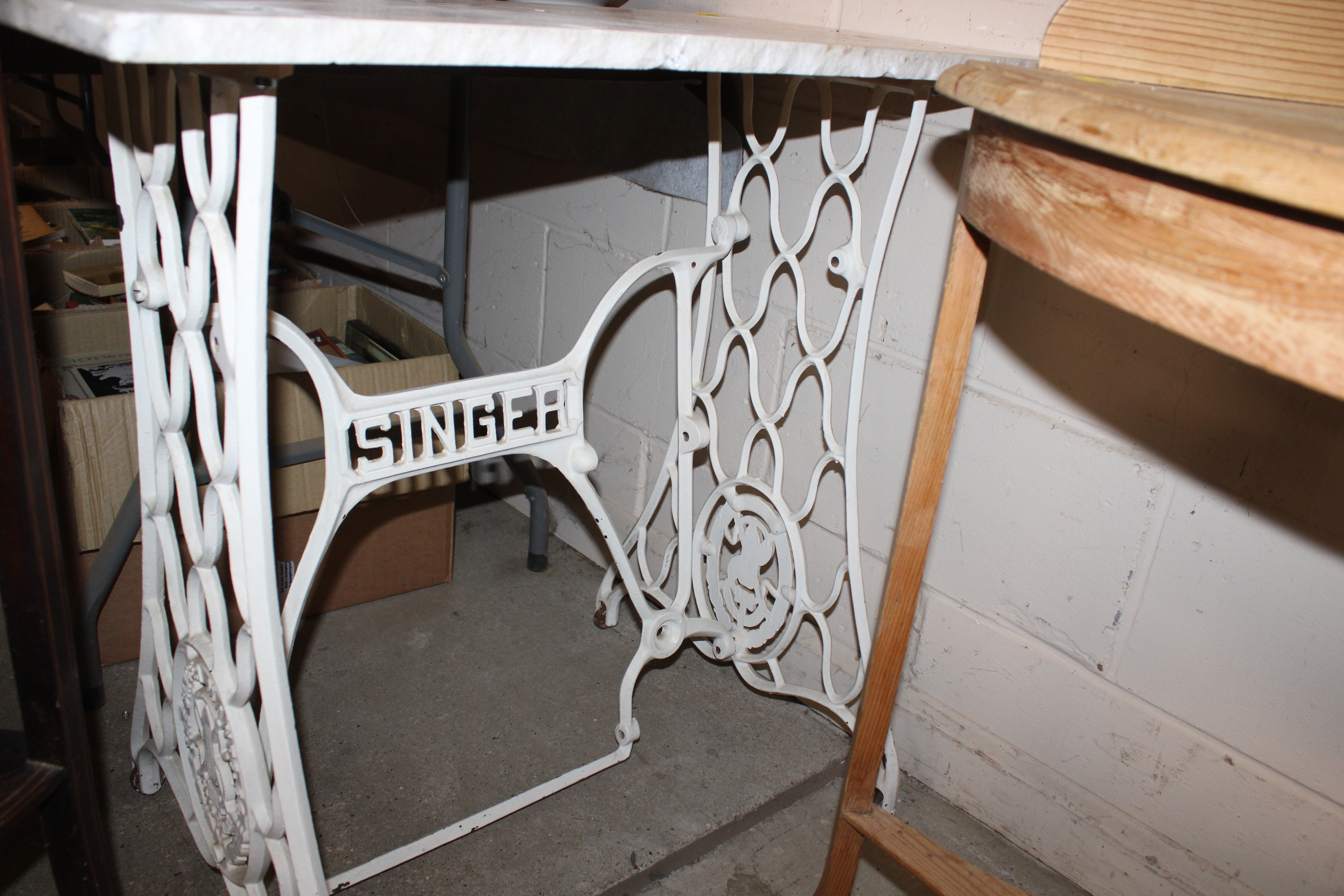 A cast iron Singer treadle sewing machine base having marble top