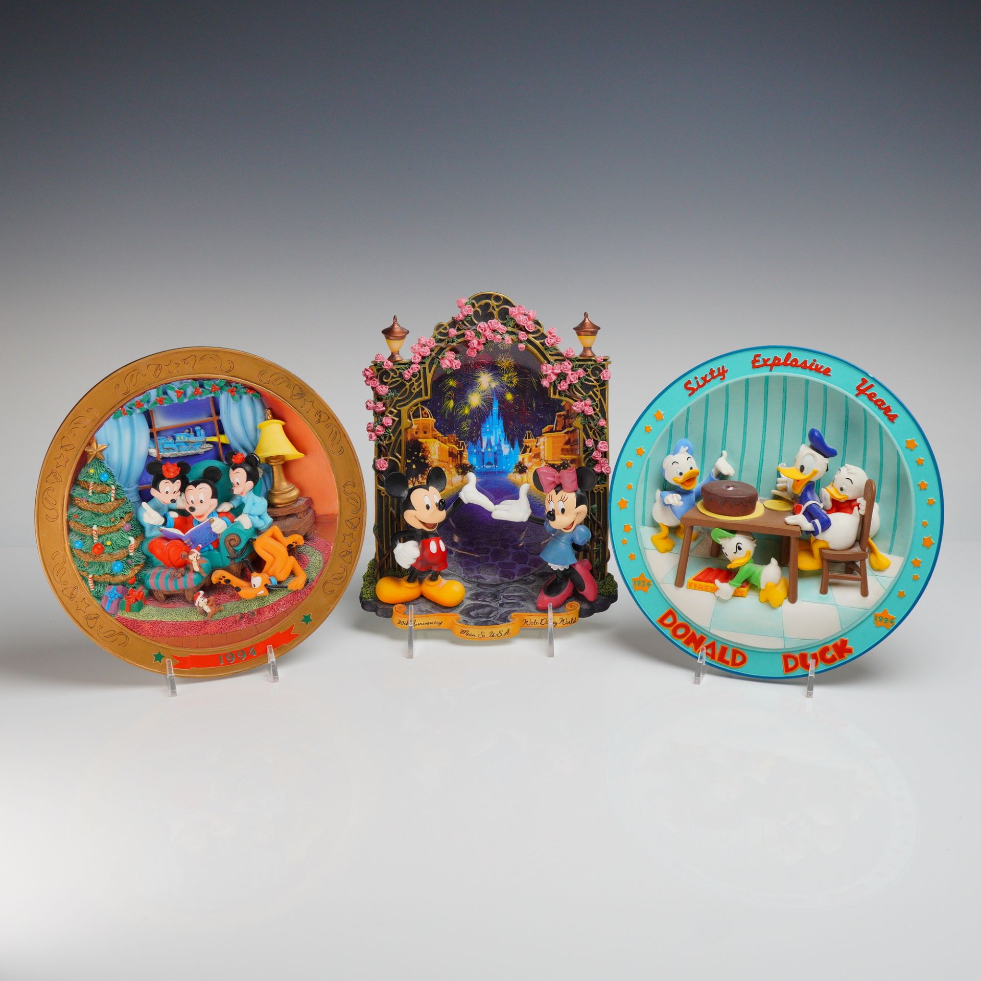 A trio of Walt Disney Collectible Wall Plates and Plaques, executed in ...