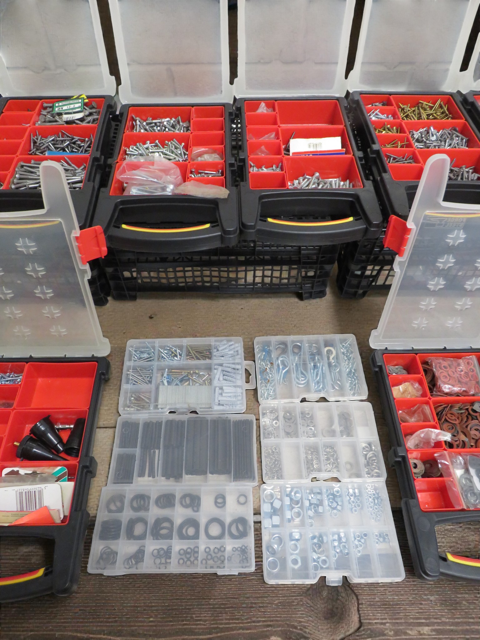 Sixteen storage organizer boxes with compartments containing assorted ...