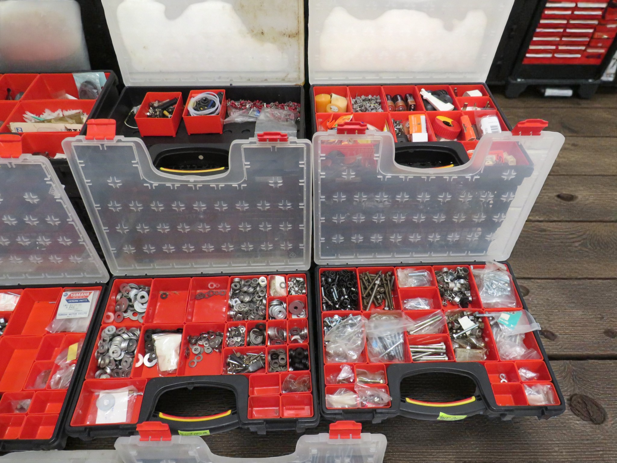Eleven storage organizer boxes with compartments containing assorted ...