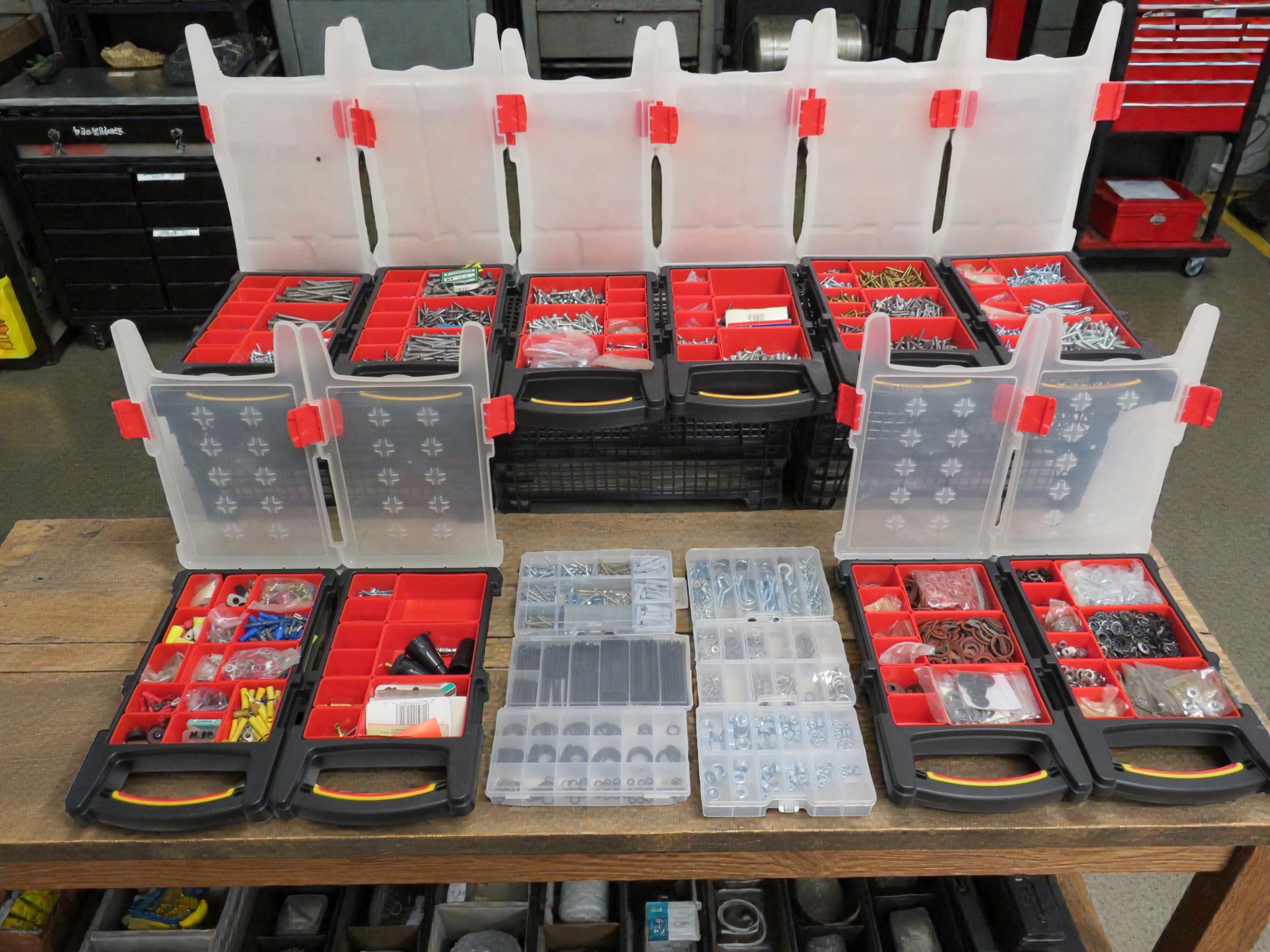Sixteen storage organizer boxes with compartments containing assorted ...