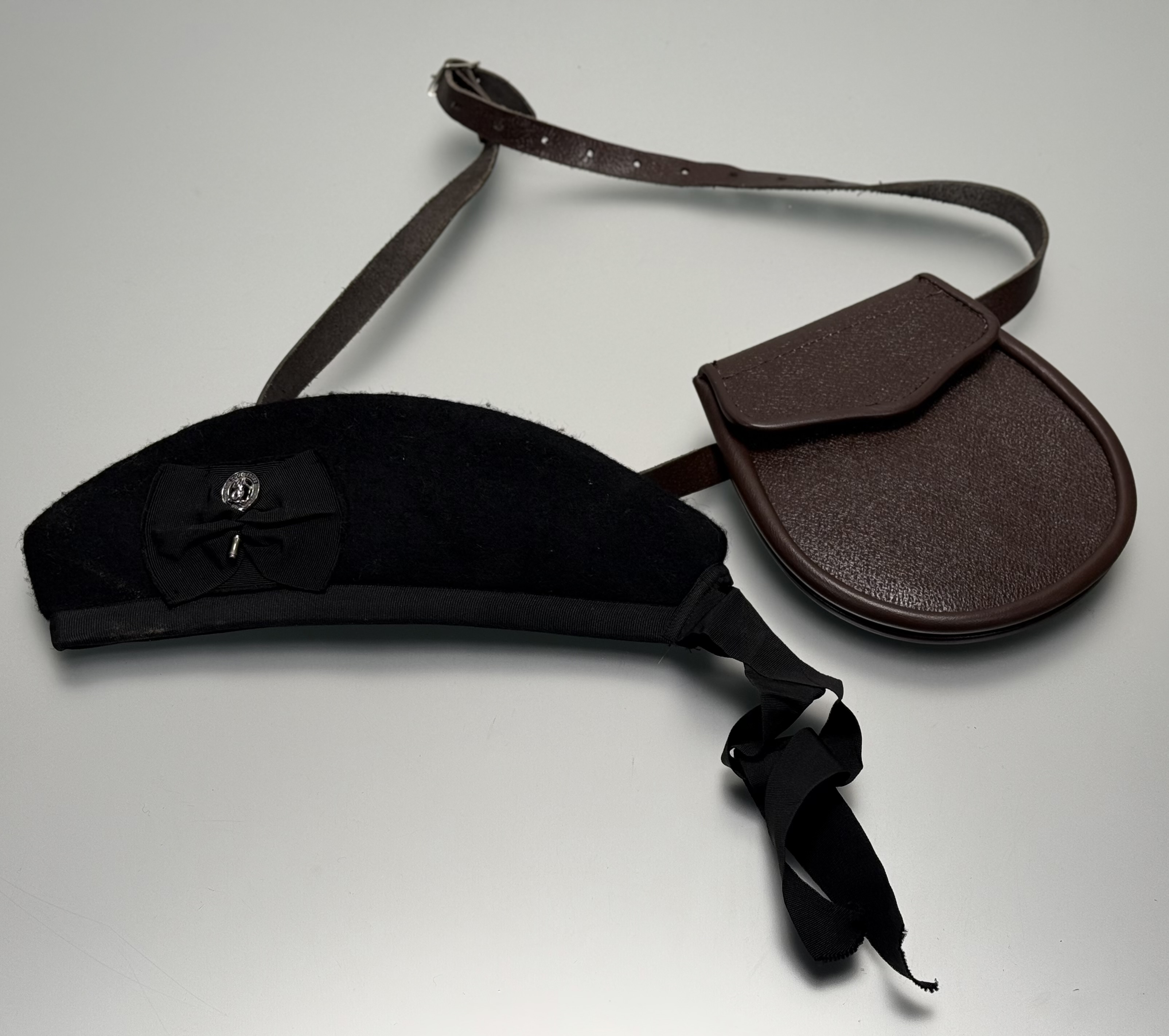 A brown leather day sporran with waist belt (19.5cm x 18cm) and a black ...