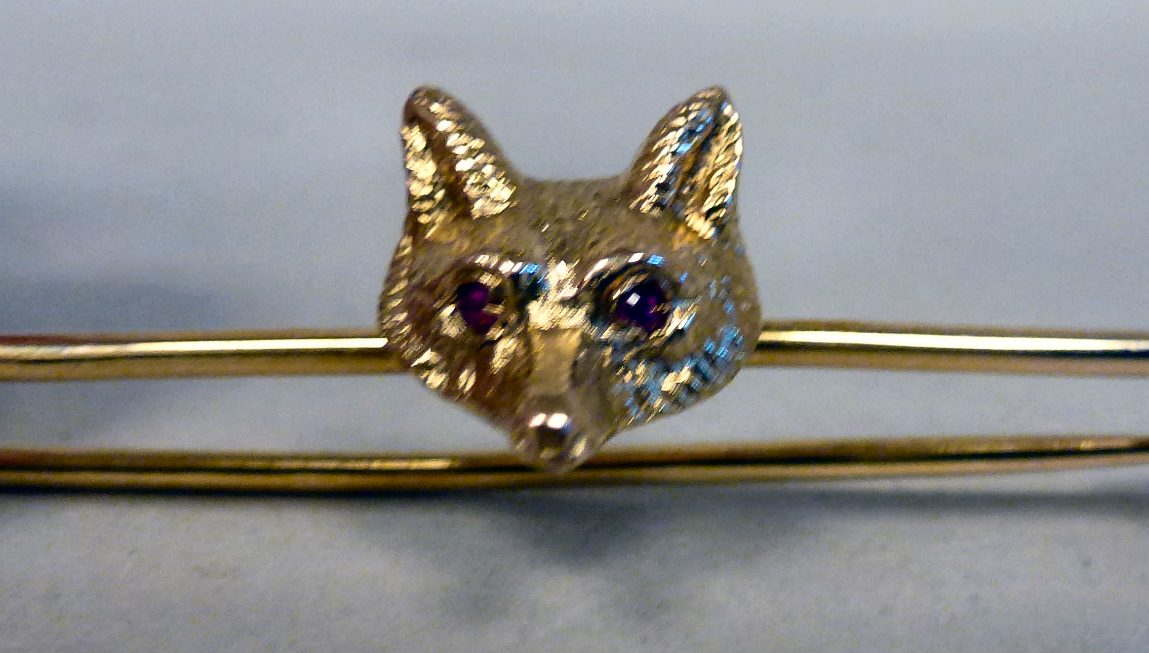 A 9ct gold bar brooch, decorated with a fox's head with red stone eyes ...