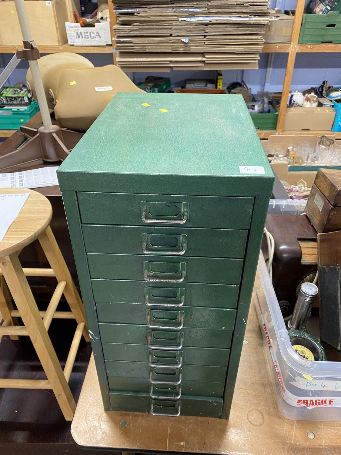 A green ten shelf tool box, with various assorted contents