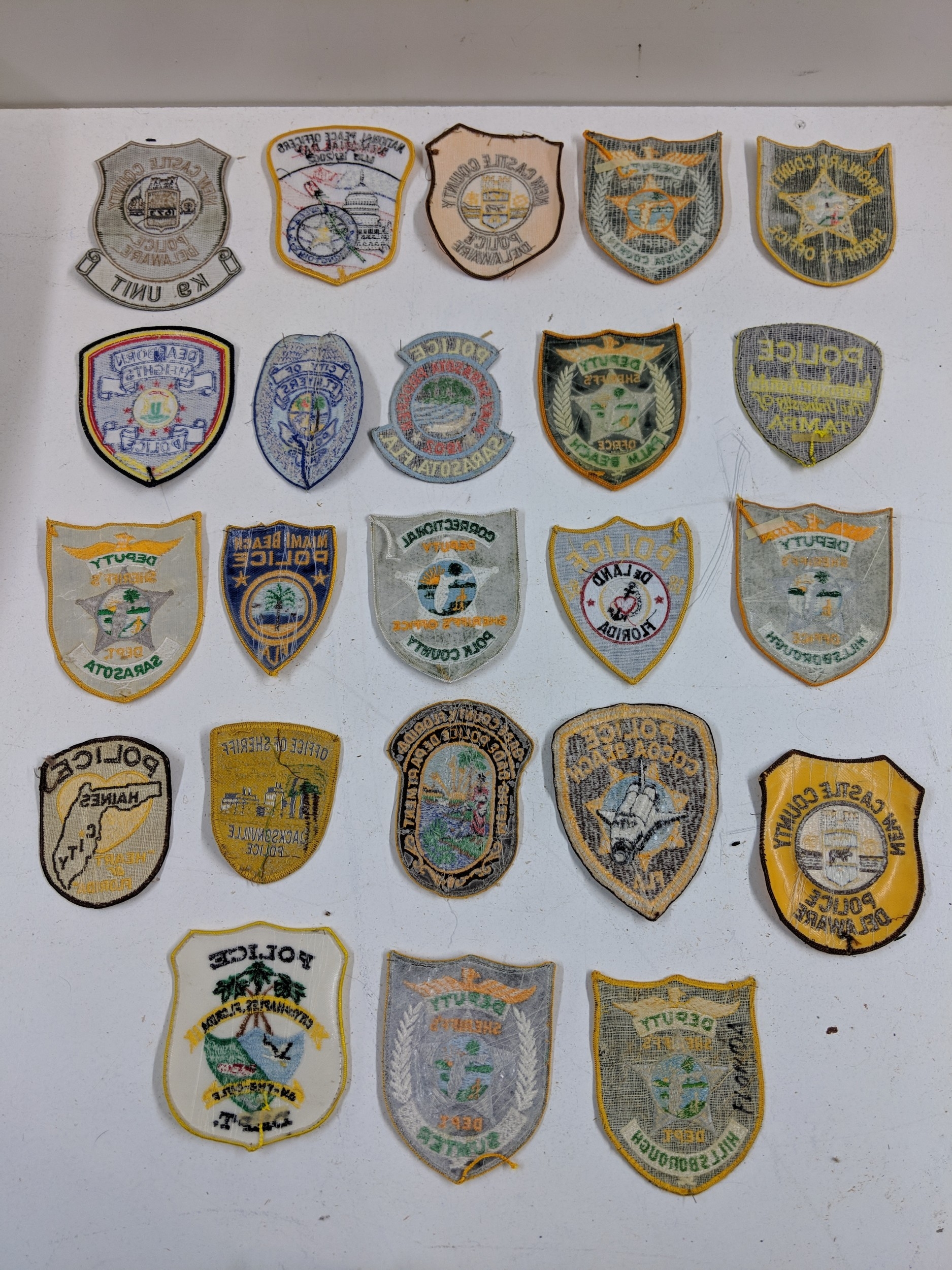Twenty-three cloth badges representing different Police Units in ...