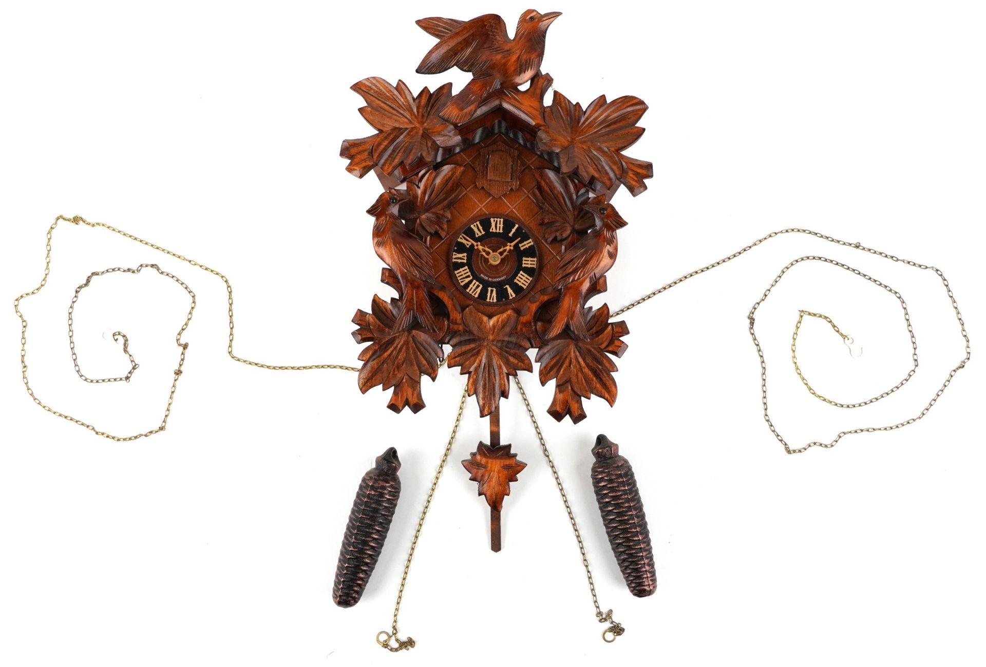 A late 20th century Black Forest carved cuckoo clock, the black painted ...