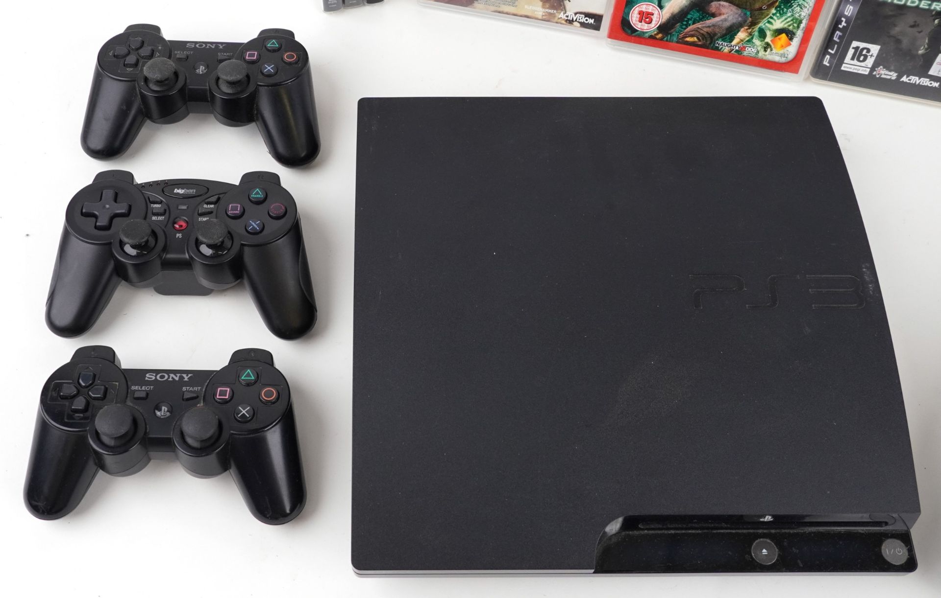 Two Sony PlayStation PS 3 games consoles with three controllers and a ...