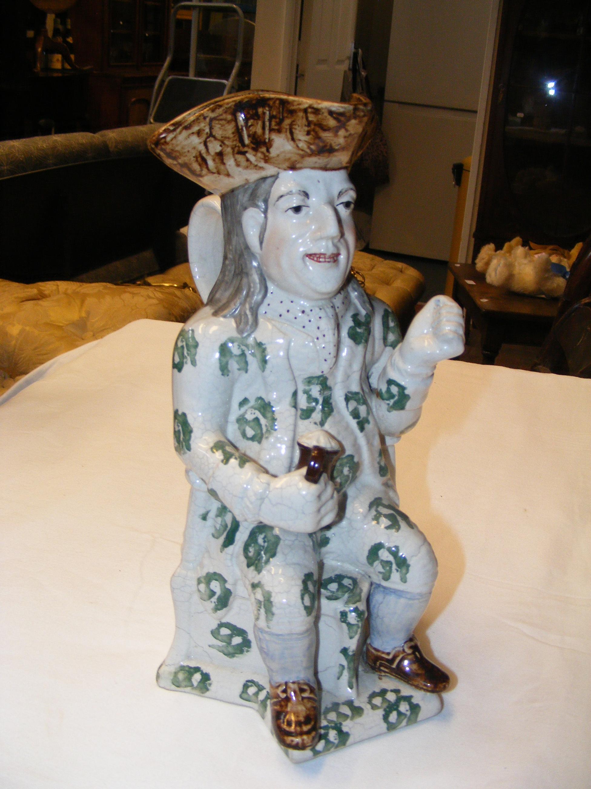 An early 19th century Squire Toby jug having green ribbon decorated ...