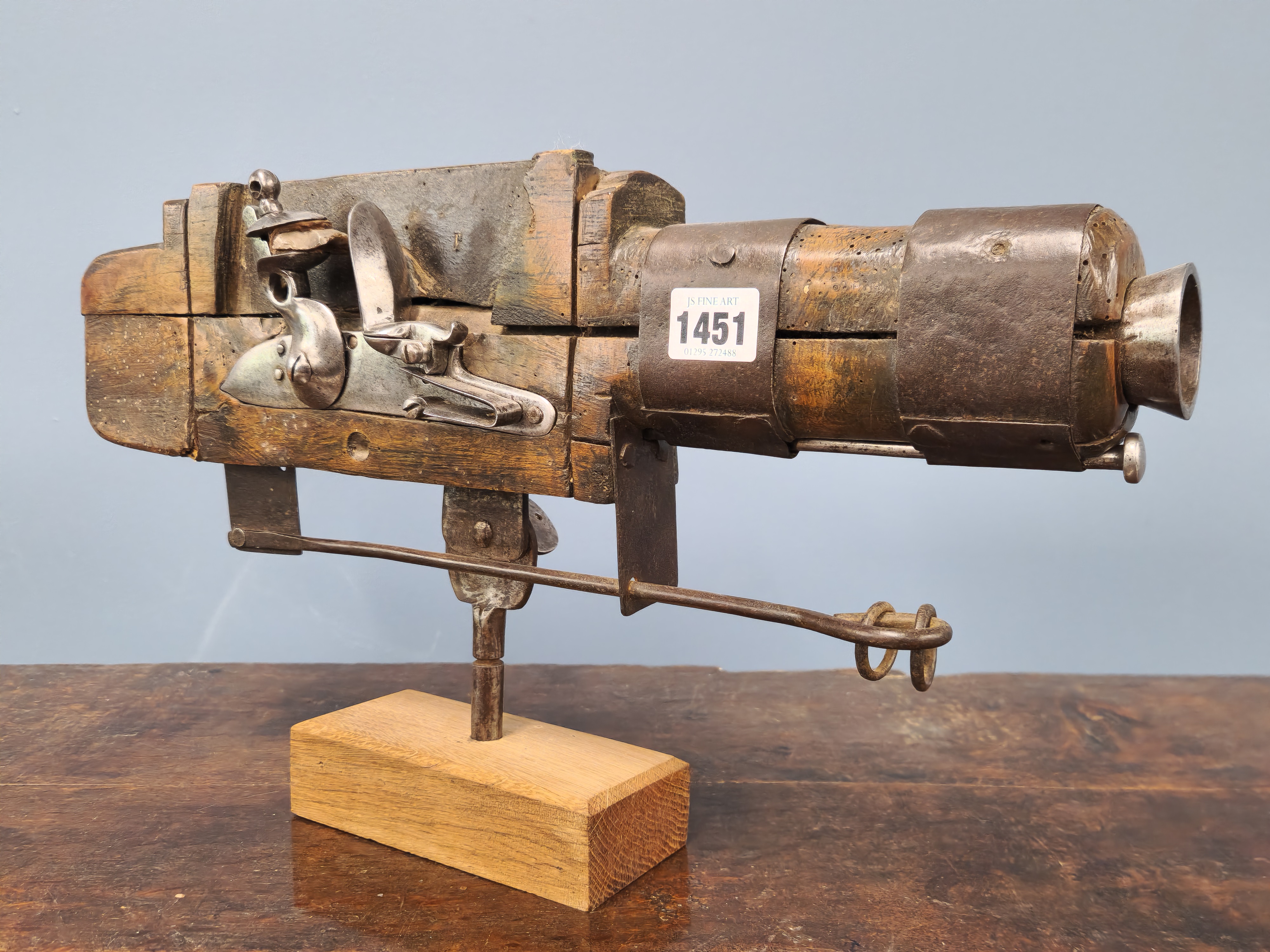 A flintlock gun firing by a trip mechanism, a ramrod below the flared ...