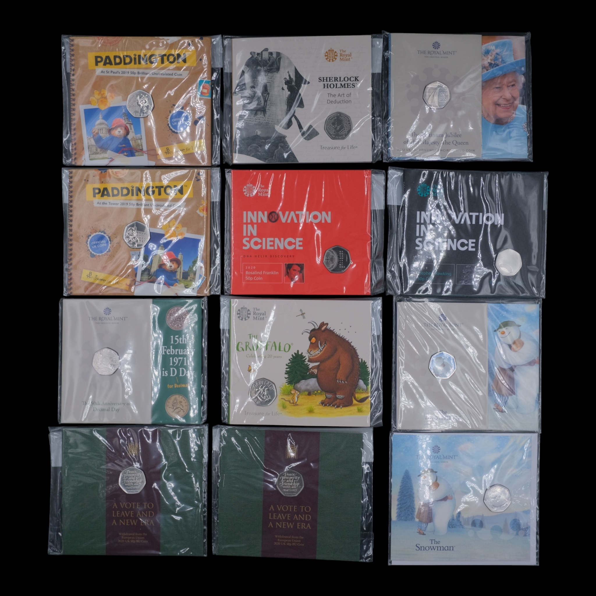 Sixteen Royal Mint BUNC 50p coin packs, including Sherlock Homes, Peter ...