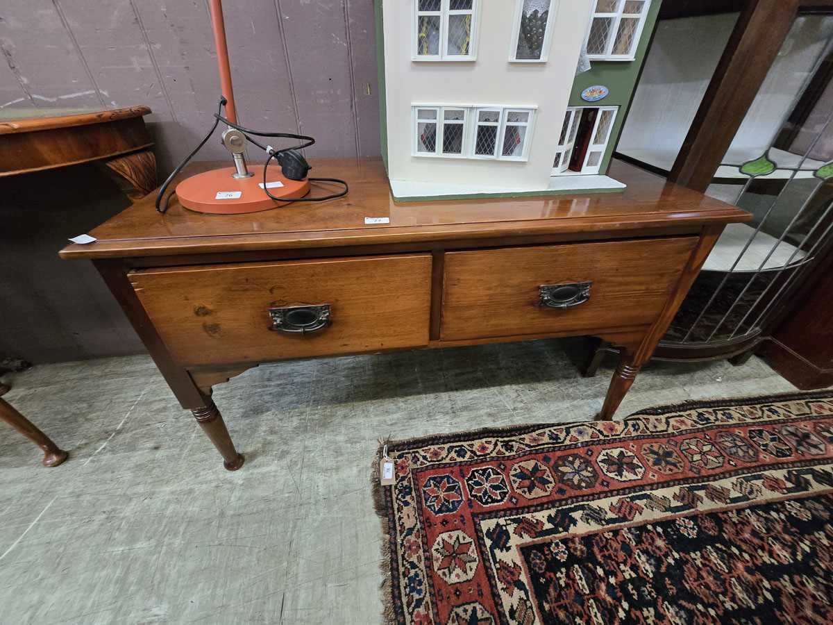 A stained pine low level table with two drawers on turned supports