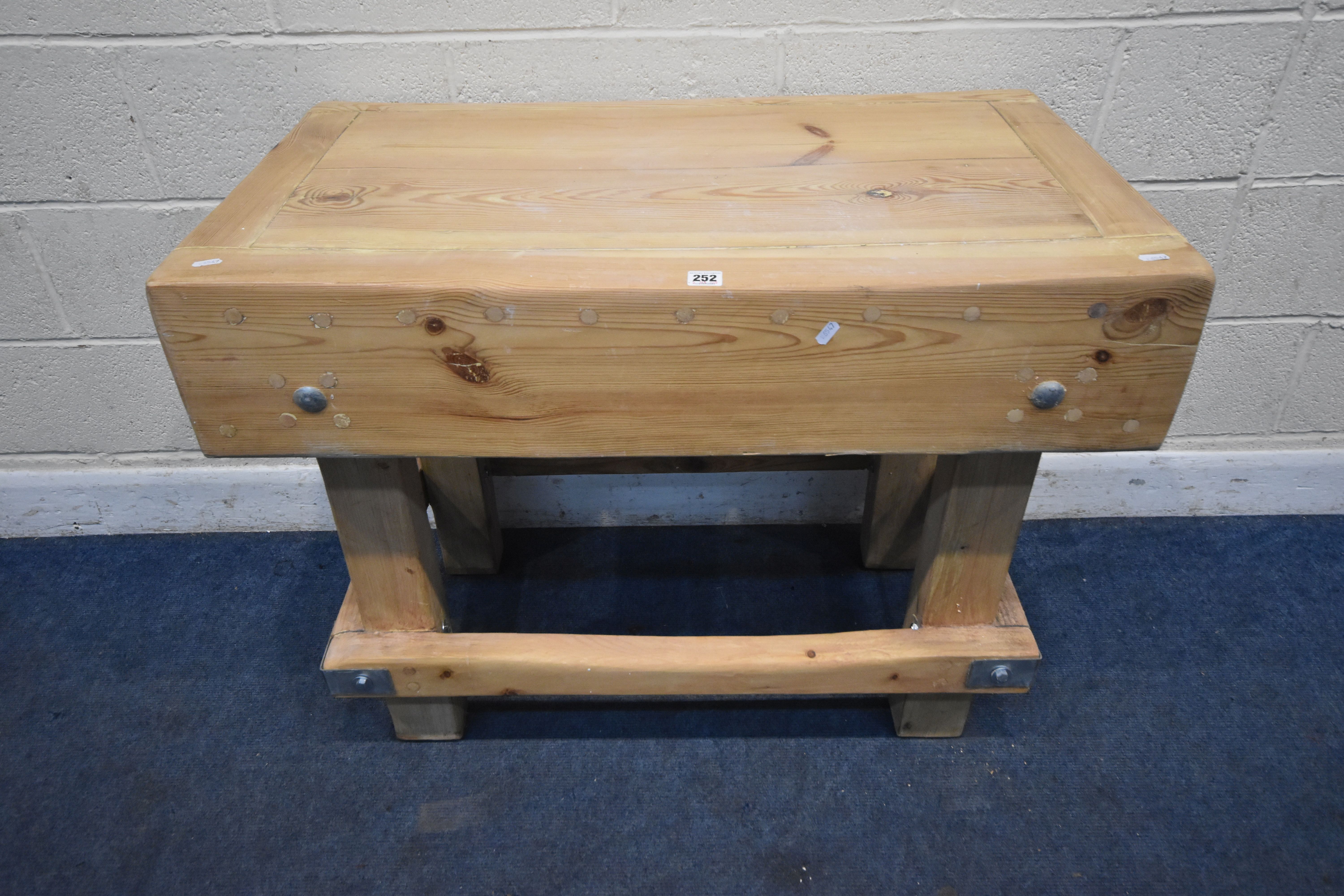 A SCRATCH BUILT BUTCHERS BLOCK, raised on block legs, united by ...