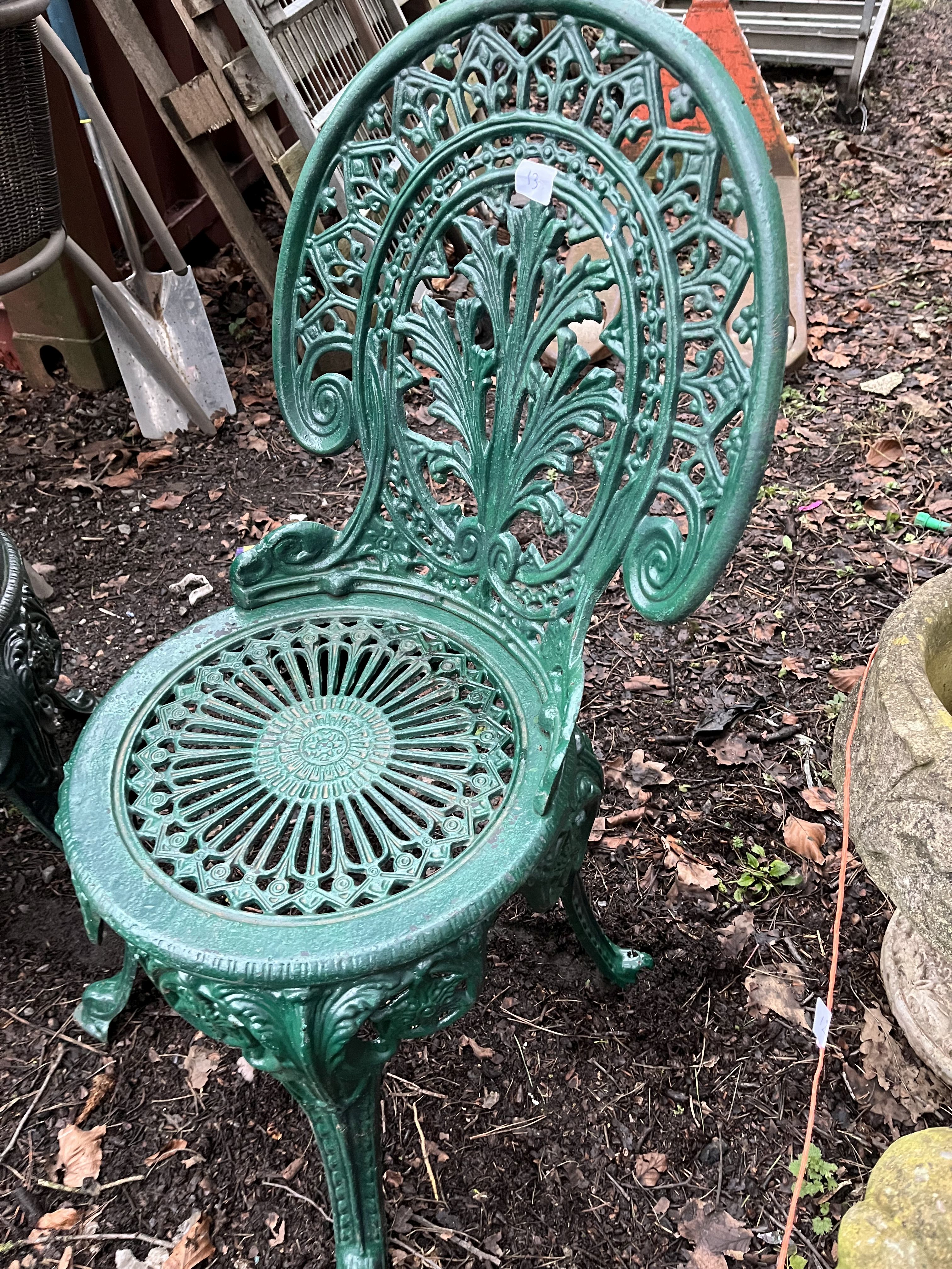A SET OF FOUR CAST IRON GARDEN CHAIRS with pierced fretwork detail to ...