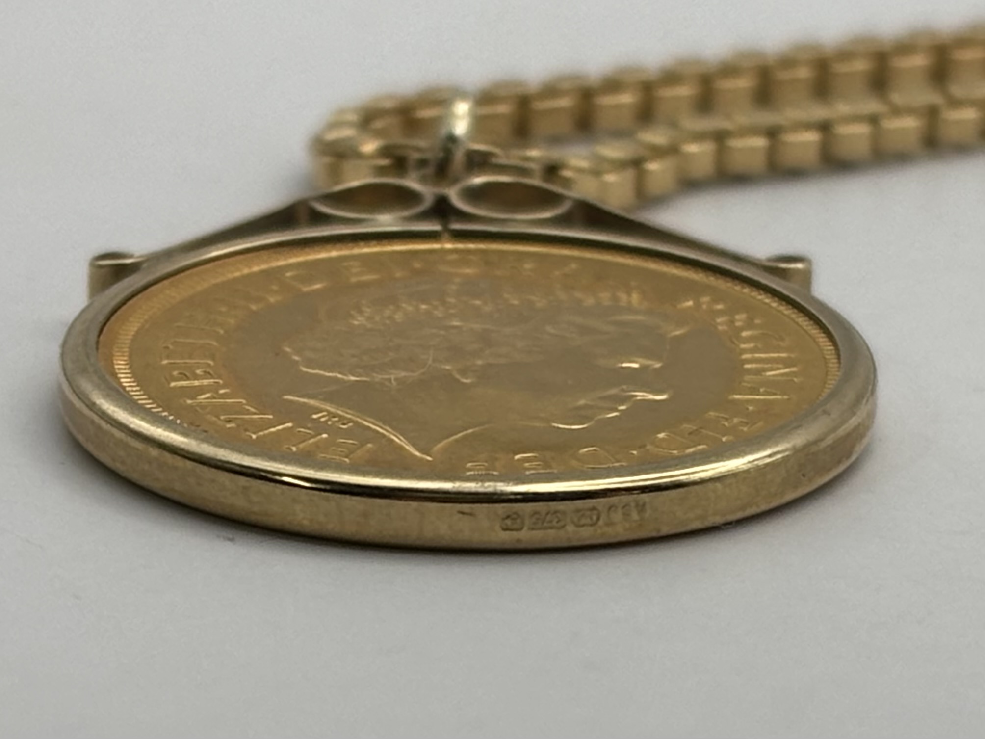 An Elizabeth II full sovereign, 2001, loose-mounted to a 9 carat gold ...
