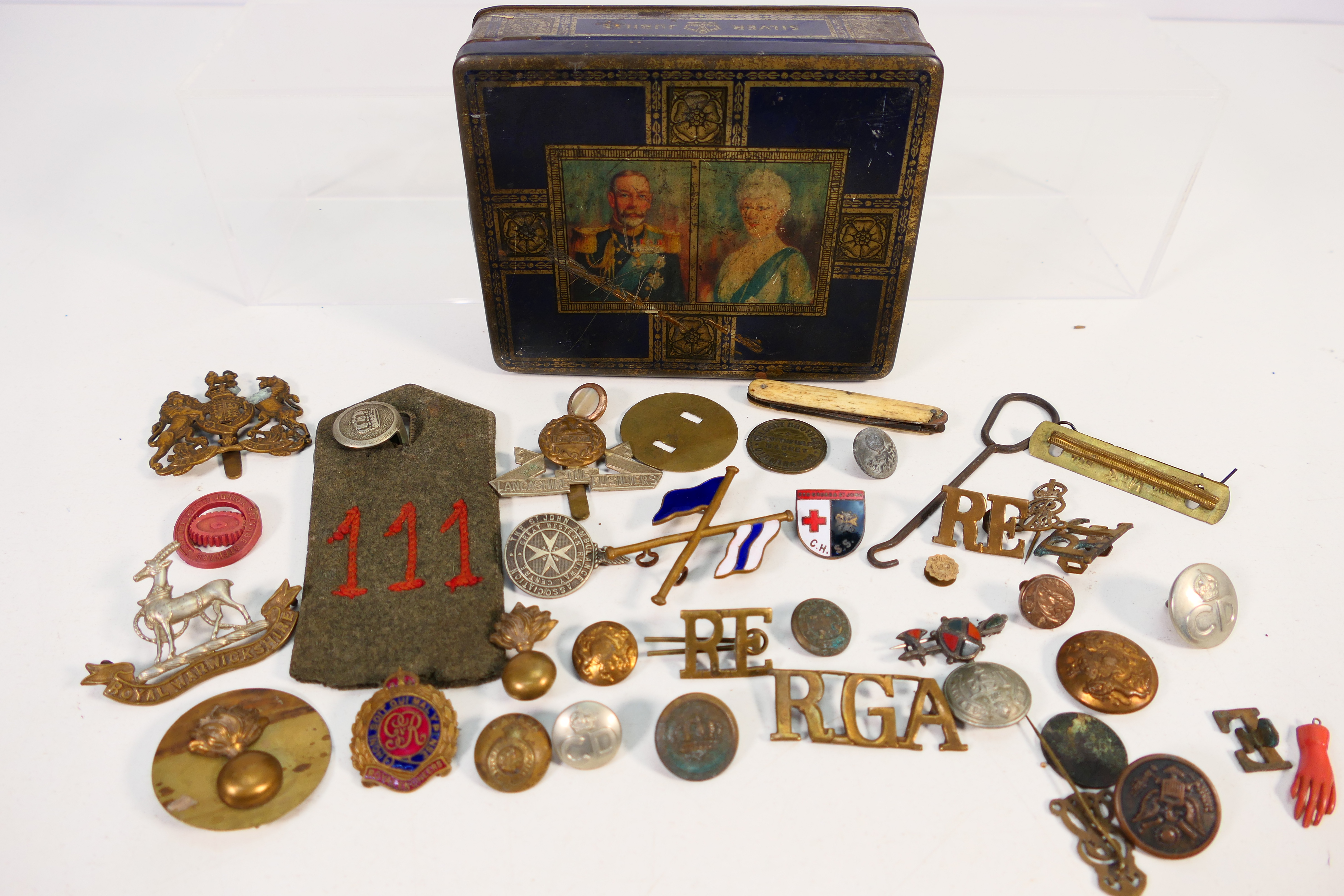 A collection of military cap badges, buttons and other insignia. [W]